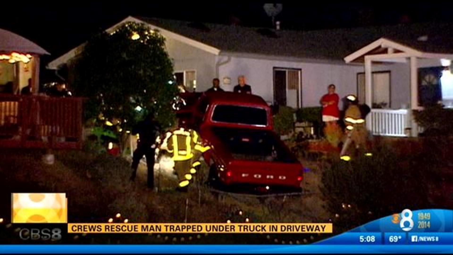 Crews rescue man trapped under truck in driveway | cbs8.com