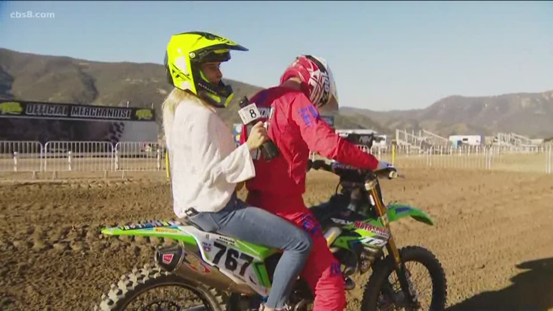 Ashley hops on the back of a motocross bike and rides around the track ...