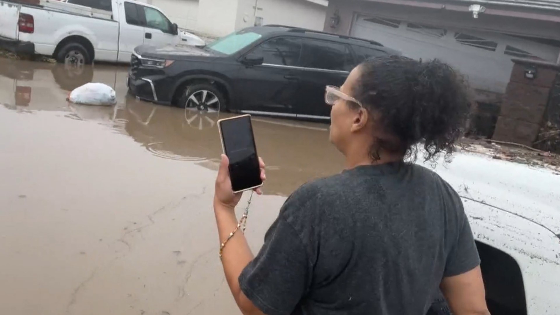 San Diego flooding | Woman walks through flood waters in Mountain View to find car | cbs8.com